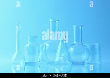 Different laboratory glassware on light blue background Stock Photo - Alamy