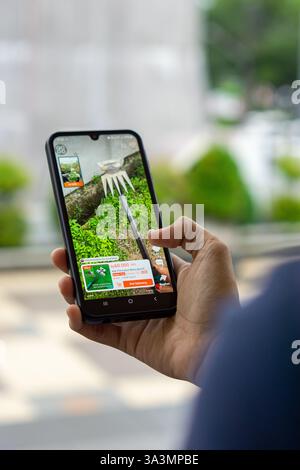 A hand is scrolling Shopee online shop Stock Photo - Alamy