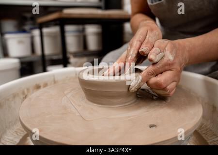 Creating a ceramic bowl by yourself in a pottery class. Wheel throwing ...