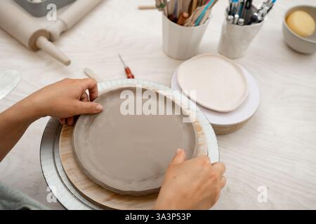 Creating ceramic products from flat sheets of clay. Using hands to ...