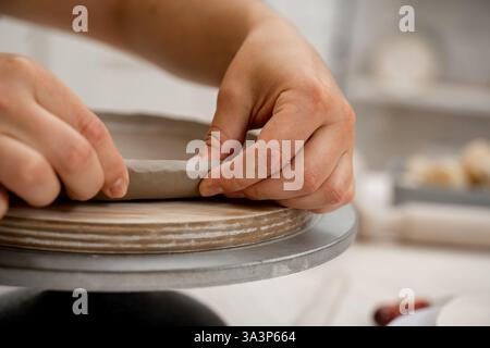 Creating ceramic products from flat sheets of clay. Using hands to ...