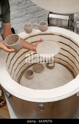 Placing pottery in a muffle furnace to heat it to high temperatures ...