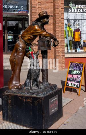 A bronze statue of a cowboy and his dog on Main Street in the historic ...