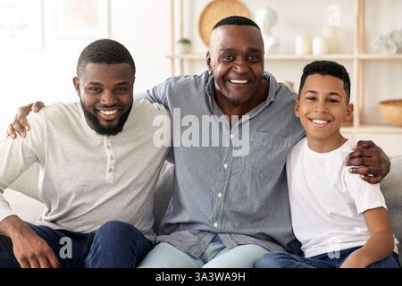 Three generations family portrait enjoying watching childhood picture ...