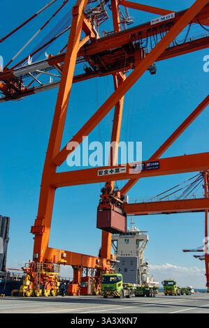 Cargo is loaded onto cargo ships at the kana container yard in Tokyo ...