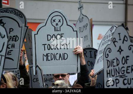 Sign at a Stop the Cuts rally against DOGE cuts to federal funding in ...