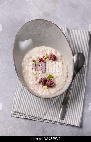 Oatmeal porridge with frozen raspberries and chopped pistachios Stock ...
