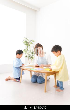 Children and teacher doing origami at the kindergarten Stock Photo - Alamy