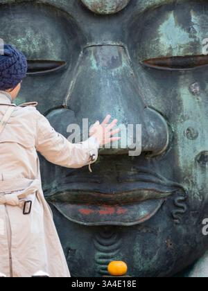Visitors touch the "Crying" Daibutsu *Great Buddha, which is located in ...
