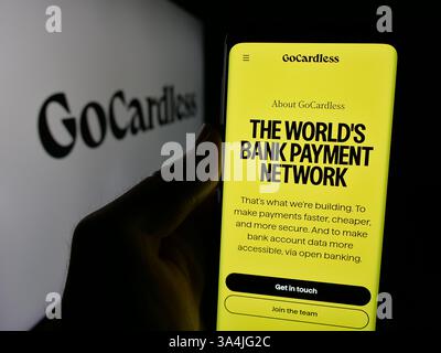 Person holding cellphone with logo of French Commission de Regulation ...