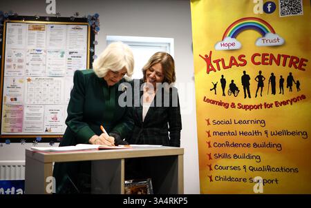 Queen Camilla signs the guest book during a visit to St Mungo's in ...