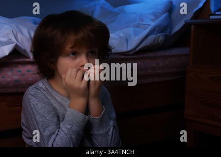 Afraid boy near his bed at night Stock Photo - Alamy