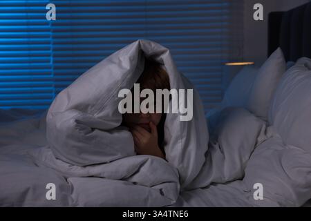 Scared boy hiding under blanket Stock Photo - Alamy