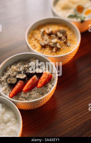 4 types of porridge in white bowls on a wooden background, oatmeal ...