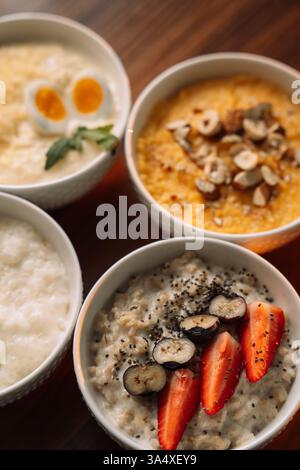 4 types of porridge in white bowls on a wooden background, oatmeal ...