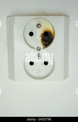 A melted and burnt electrical outlet, illustrating a significant fire ...