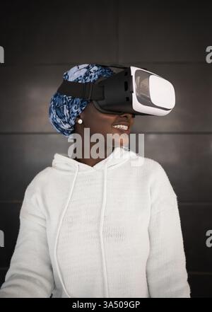 Brunette woman wearing virtual vr goggles. Young famale in a black top ...