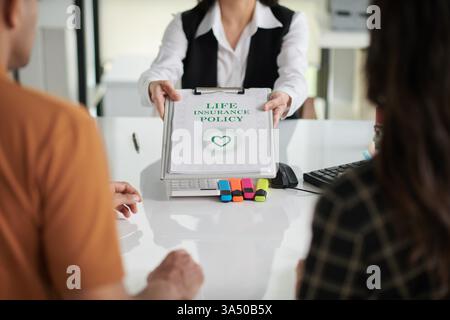 Agent giving life insurance policy to young couple Stock Photo - Alamy