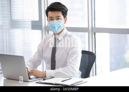 Businessman wearing face mask working in office Stock Photo - Alamy