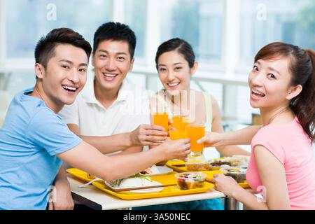 Young Chinese adults celebrating with orange juice Stock Photo - Alamy