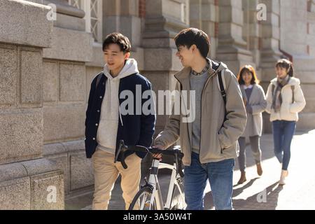 Happy Chinese college students walking on campus Stock Photo - Alamy