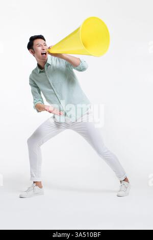 Chinese woman shouting on megaphone holding on whiteboardwhile standing ...