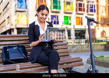 Dreamy smiling asian woman using mobile phone, sitting and relaxing at ...