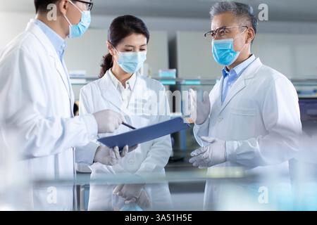 Three Chinese researchers discussing in laboratory Stock Photo - Alamy