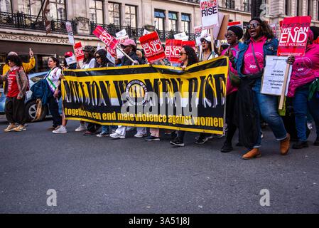 Protestors hold a large banner and placards during the "Say No To ...