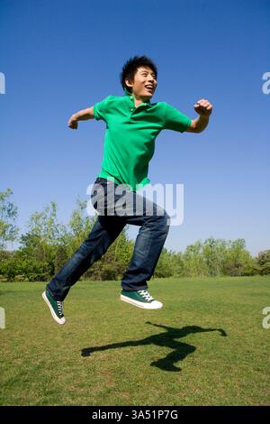 Young Chinese man jumping in air at park Stock Photo - Alamy