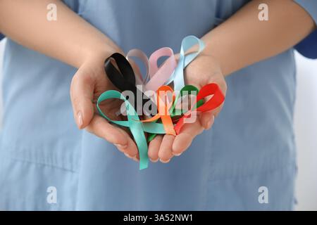 Female doctor with different awareness ribbons on white brick ...