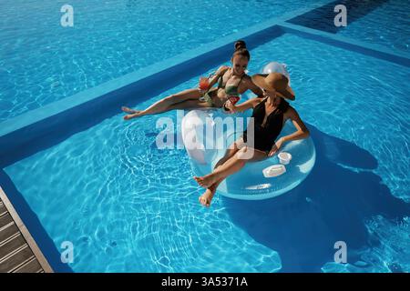 Chilling in the pool. Two beautiful women are resting Stock Photo - Alamy