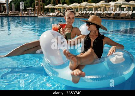 Chilling in the pool. Two beautiful women are resting Stock Photo - Alamy