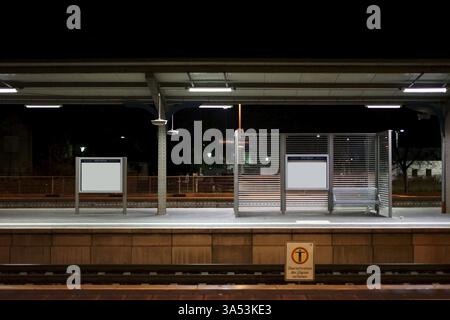 Platform of Weinheim station at night, seats at glass partition wall ...