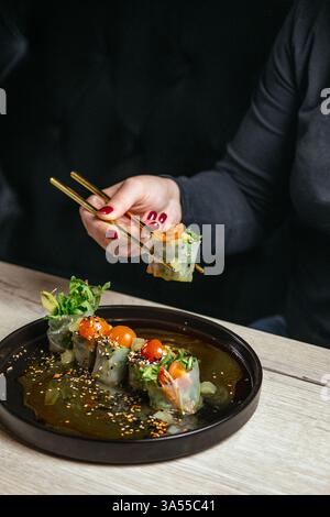 Plate with vietnamese leaves and rice noodles, spicy sauce for soup or ...