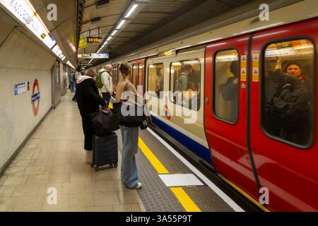 Crowded underground tube train arriving at station platform, Kings ...