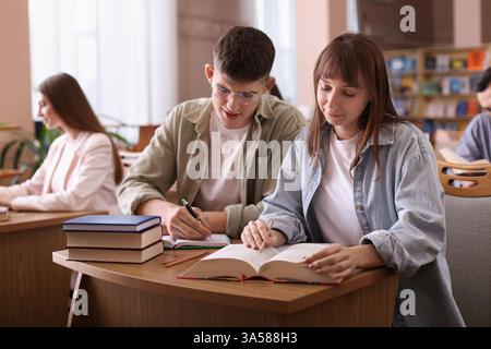 People reading different books at desks in public library Stock Photo ...