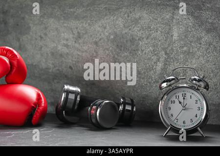 Alarm clock, boxing gloves and dumbbells on grey background Stock Photo ...