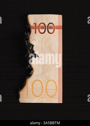 Burnt hundred Dominican peso banknote in hand. Selective focus Stock ...