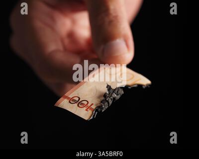 Burnt hundred Dominican peso banknote in hand. Selective focus Stock ...