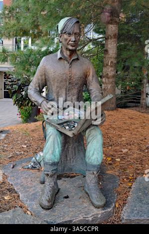 A bronze sculpture of a man stands in a modern building at an ...