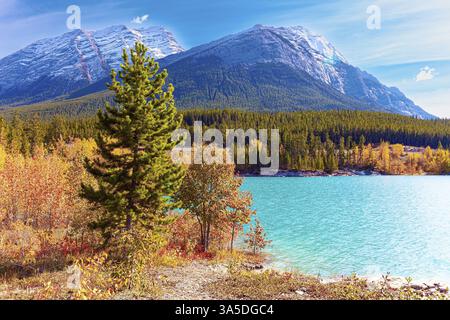 Snow-covered rocky mountaintops surround pristine alpine lakes on a ...