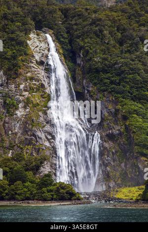 Magnificent waterfall crashes down from the cliff. Tourist cruise ...