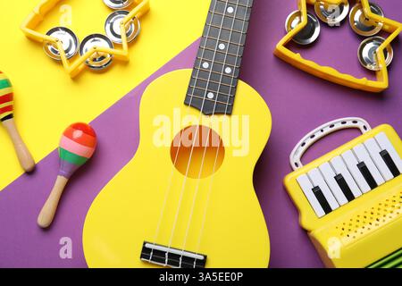 Flat lay composition with different toy musical instruments on violet ...