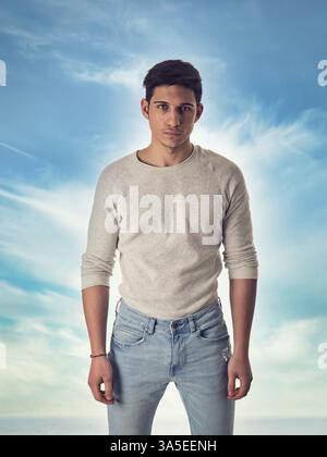Young man standing over blue background covering one eye with hand ...