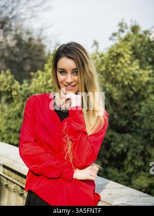 partial view of young woman in bathrobe holding damaged hair isolated ...
