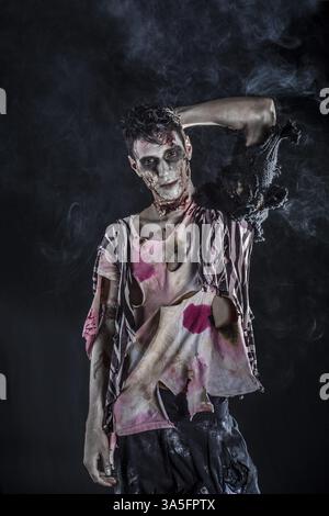 Male zombie standing on black background, turning around looking at ...
