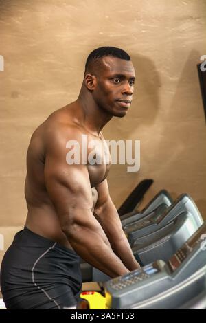 Hunky muscular black male bodybuilder exercising and jogging on ...
