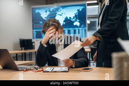 More paper work, boring, tired. Senior man is in the office with ...