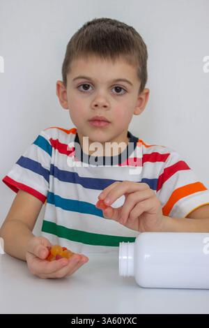 The boy eats jelly beans or takes vitamins Stock Photo - Alamy